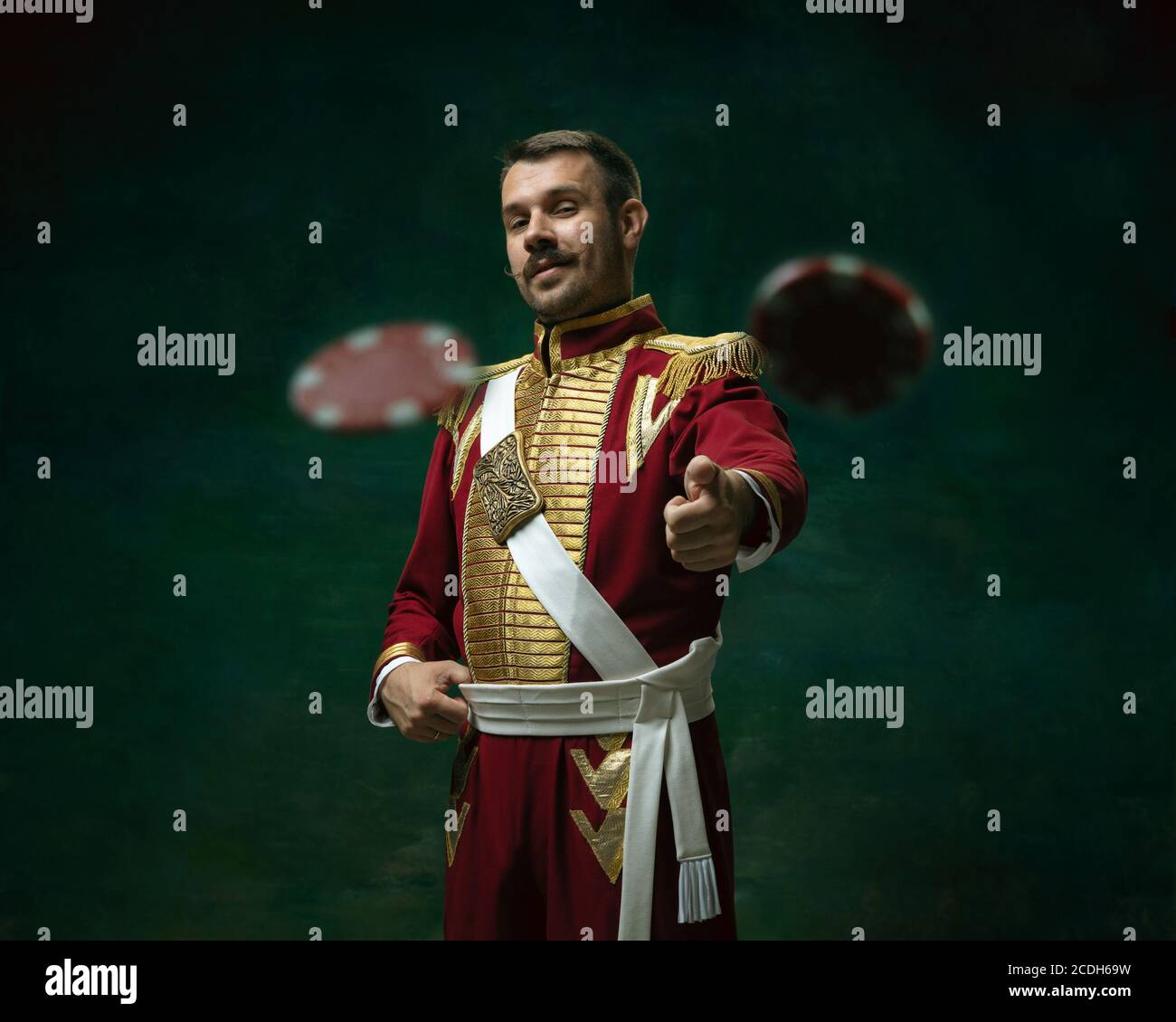 Casino winner. Young man in suit as Nicholas II isolated on dark green ...