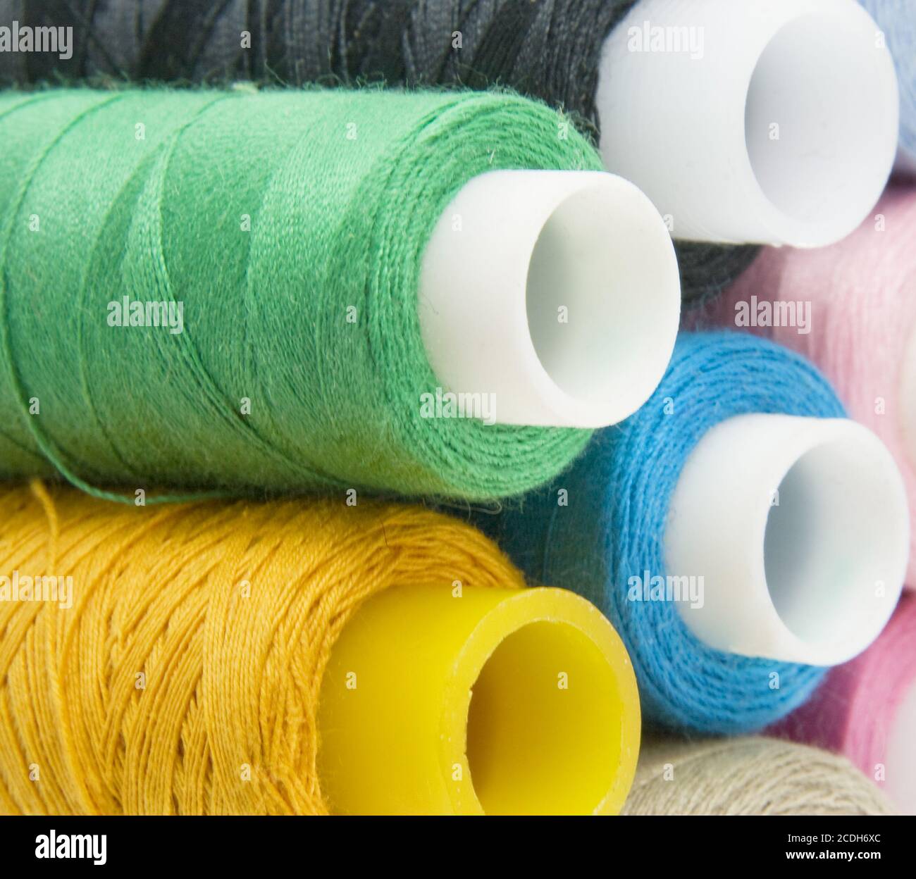 Many colorful different threads over background Stock Photo - Alamy