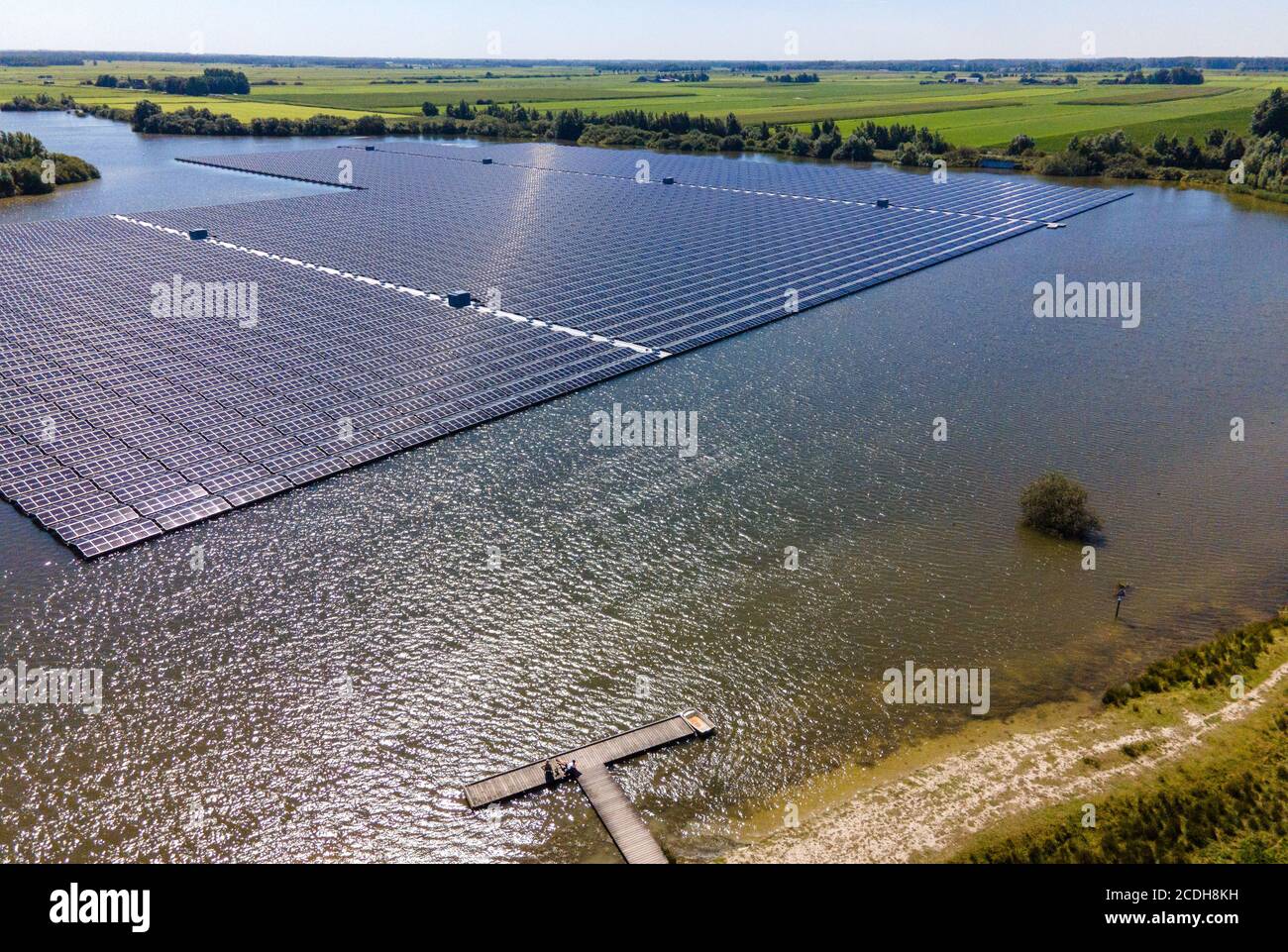 People on jetty enjoying beautiful landscape with floating solar panels ...