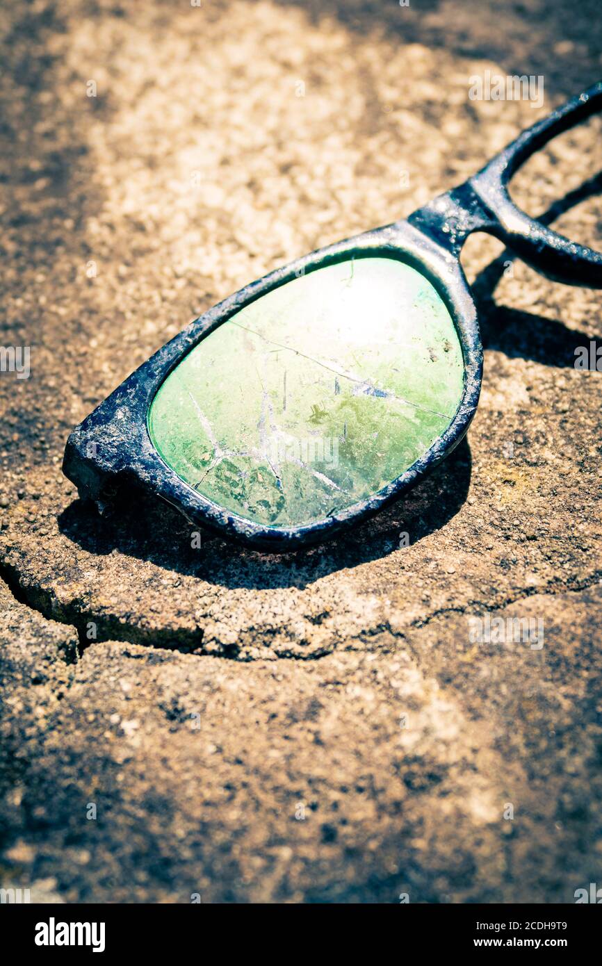 Broken sunglasses lying on a stone surface Stock Photo - Alamy