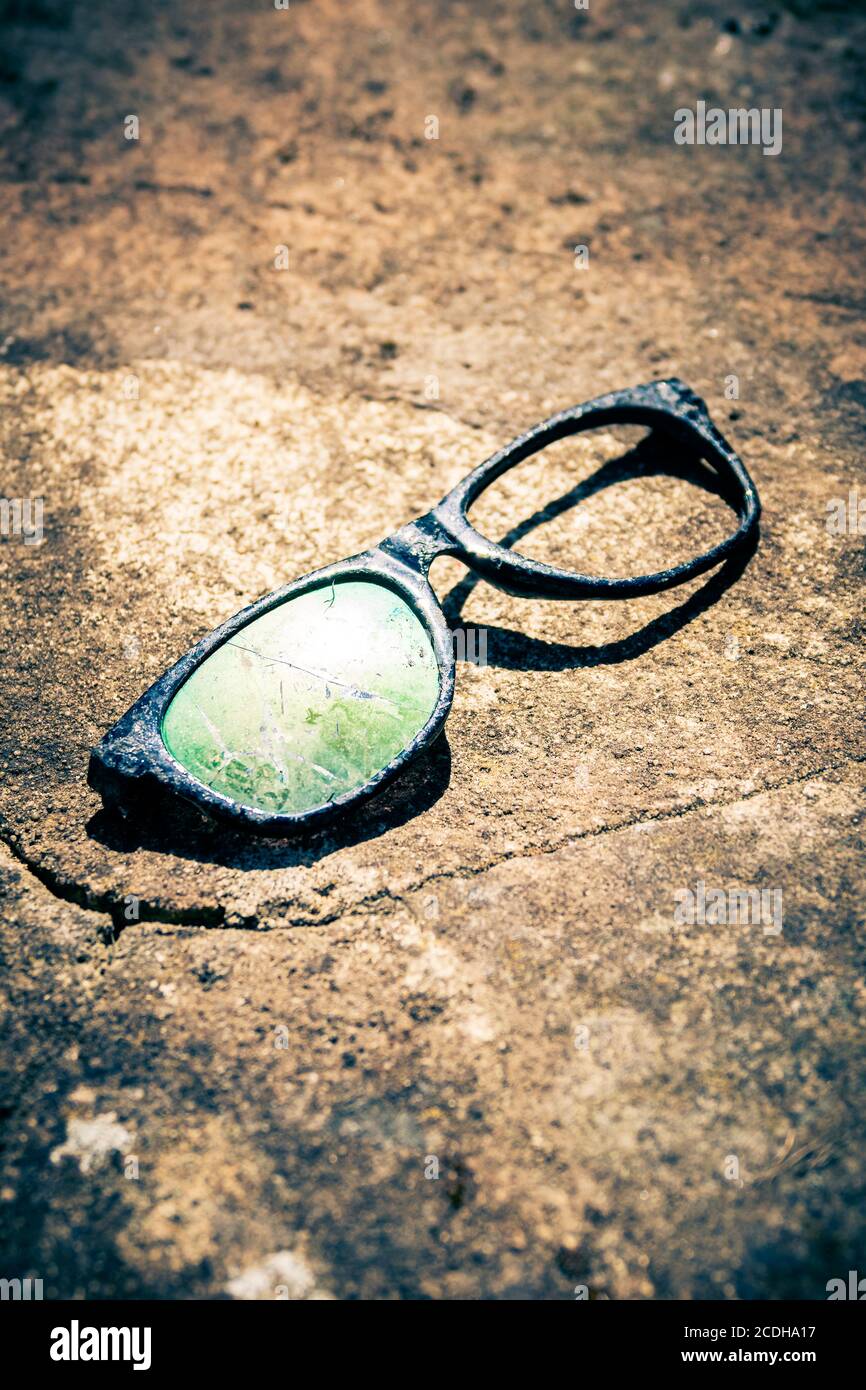 Broken sunglasses lying on a stone surface Stock Photo - Alamy
