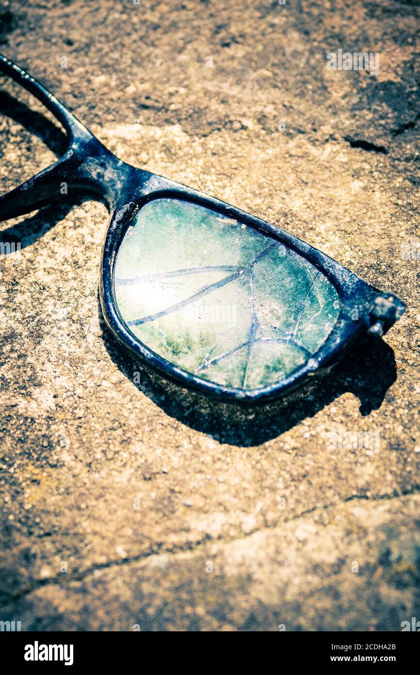 Broken sunglasses lying on a stone surface Stock Photo - Alamy