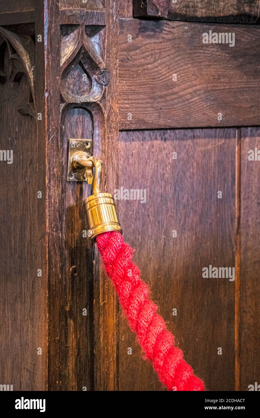 A red rope across the entrance to a wooden pew in an old church Stock ...