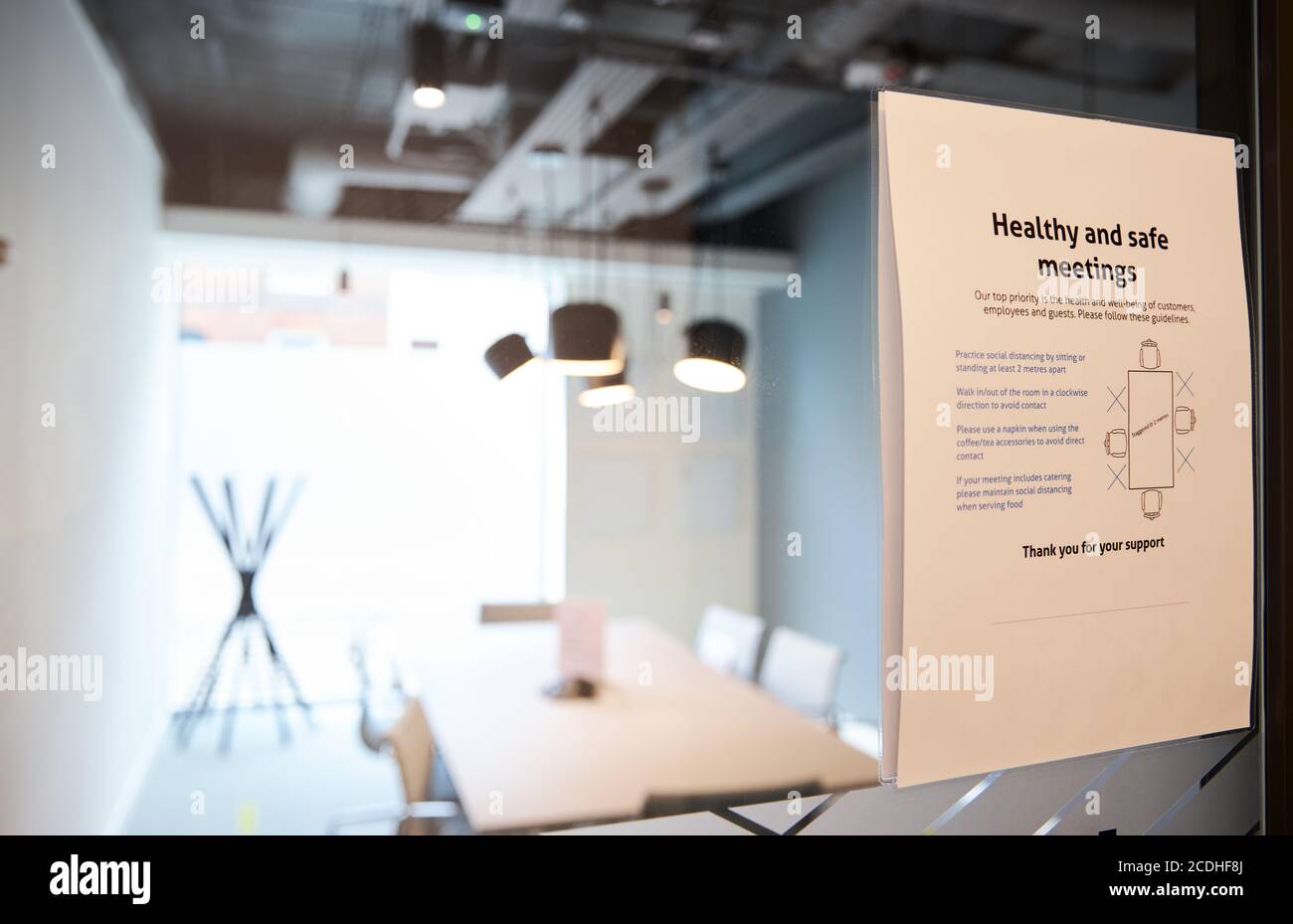 Social distancing sign on meeting room door with meeting room in ...