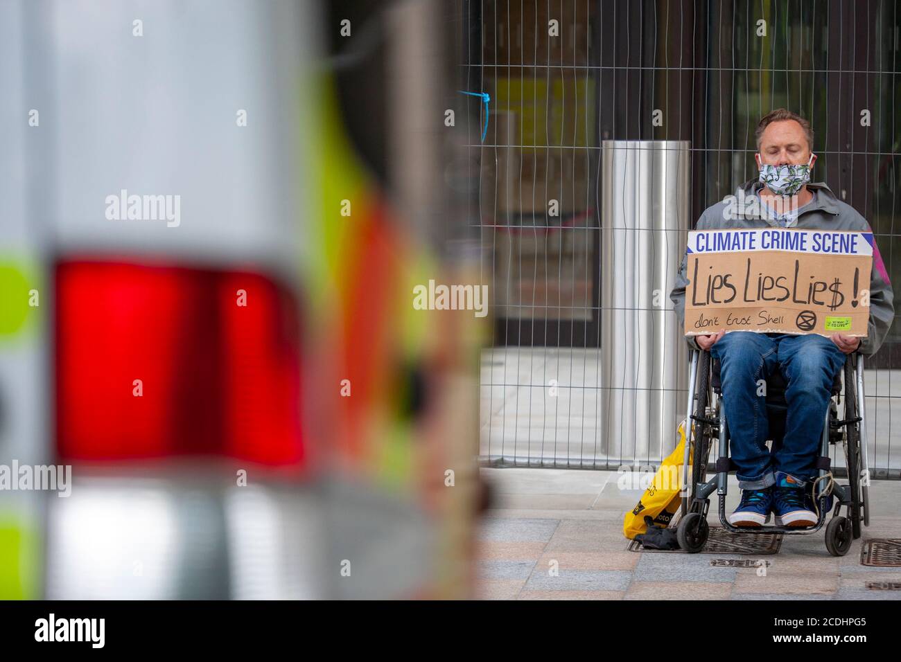 London, UK. 28th August 2020. A man sits in a wheelchair in front of ...