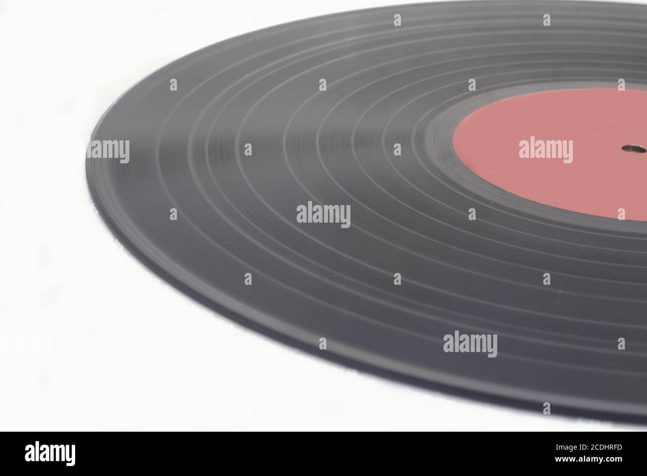12-inch LP vinyl record disk with blank red label. Close-up shot, top ...