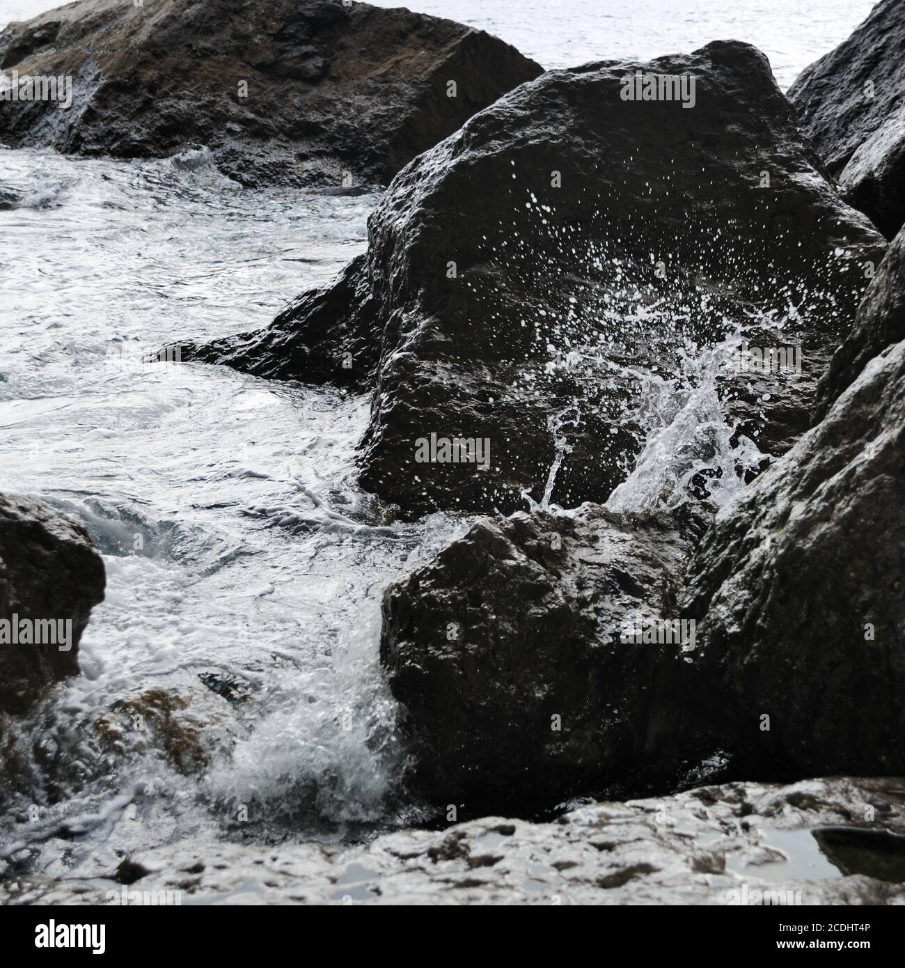 Splash of waves about coastal stones Stock Photo - Alamy
