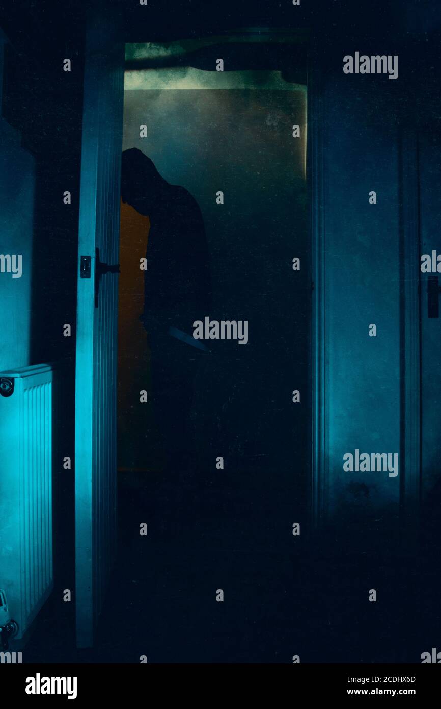 A Halloween concept of a blurred scary, hooded figure, standing in a ...