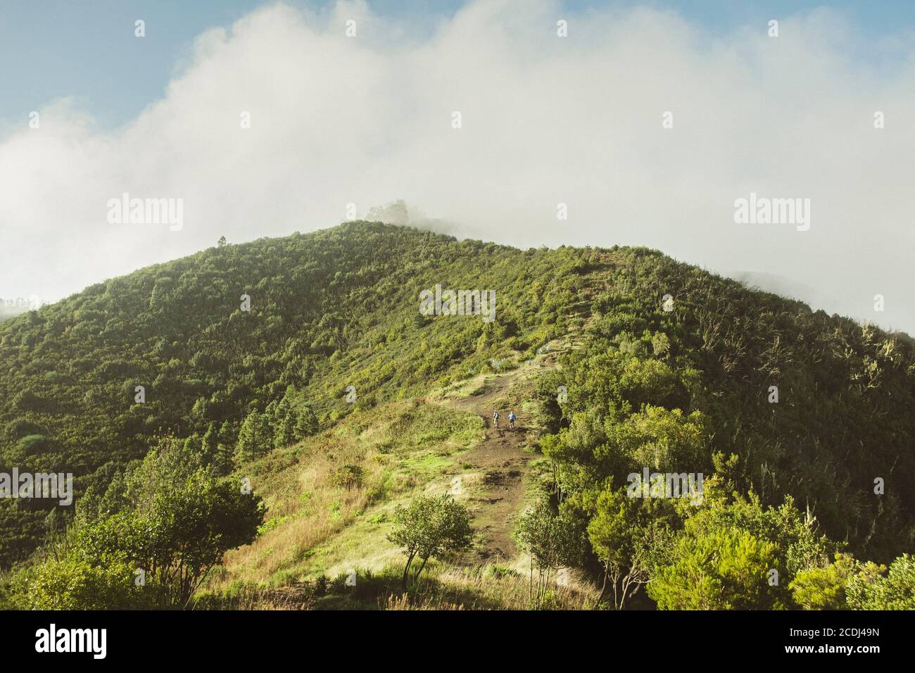 Pulled back view of two cyclists riding on mountain ridge Stock Photo ...