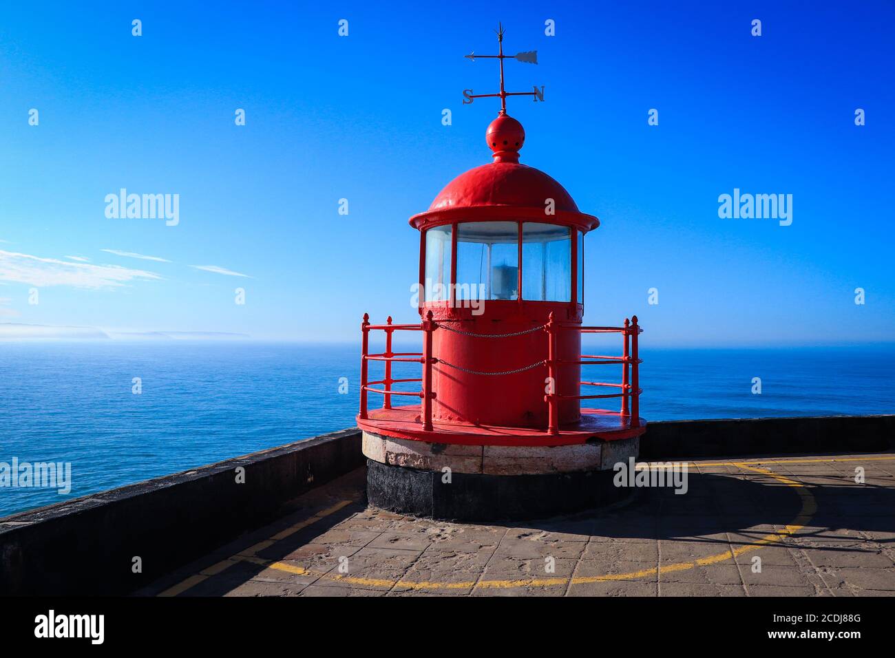 Red lighthouse lamp room on blue sky and sea background in Nazare Stock ...