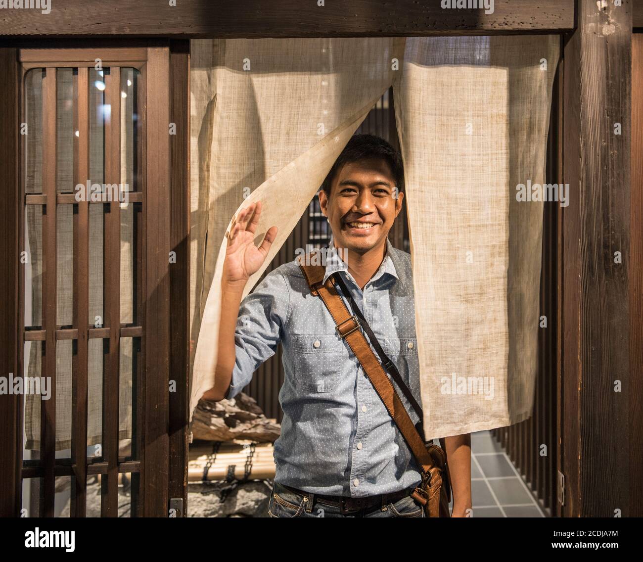 Man exiting a house in Japan through traditional Noren Stock Photo - Alamy