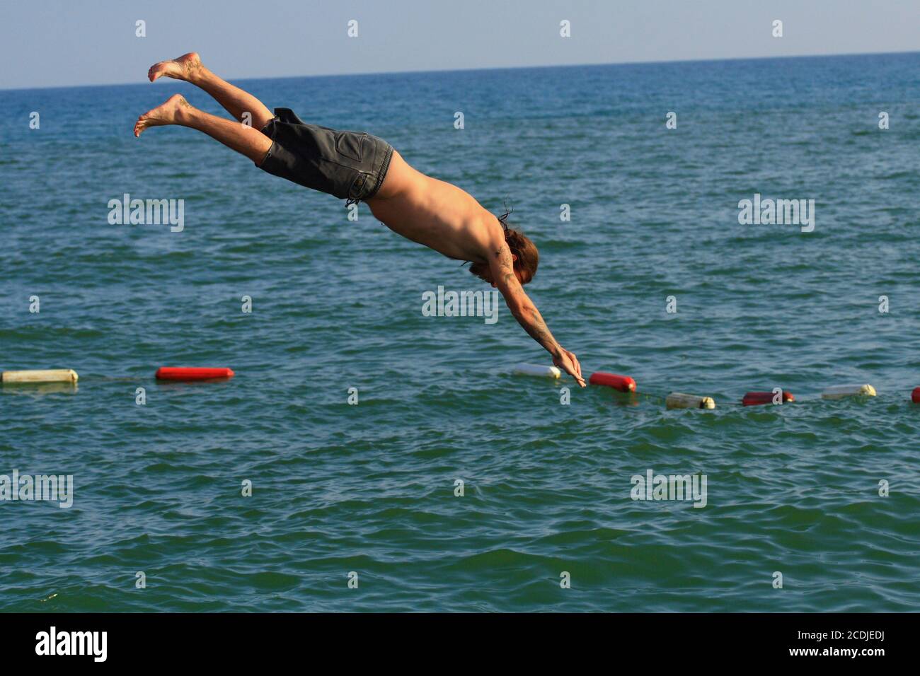 Man jumping into the sea Stock Photo - Alamy