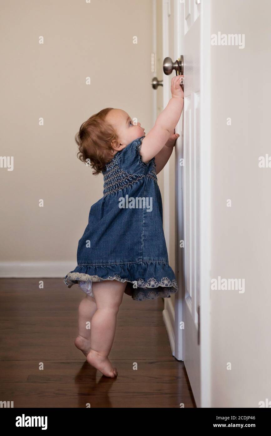 Toddler Reaching for Door Knob Stock Photo - Alamy