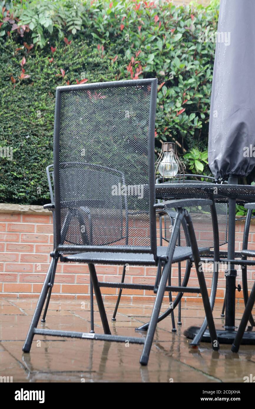 a wet metal chair on a patio Stock Photo - Alamy