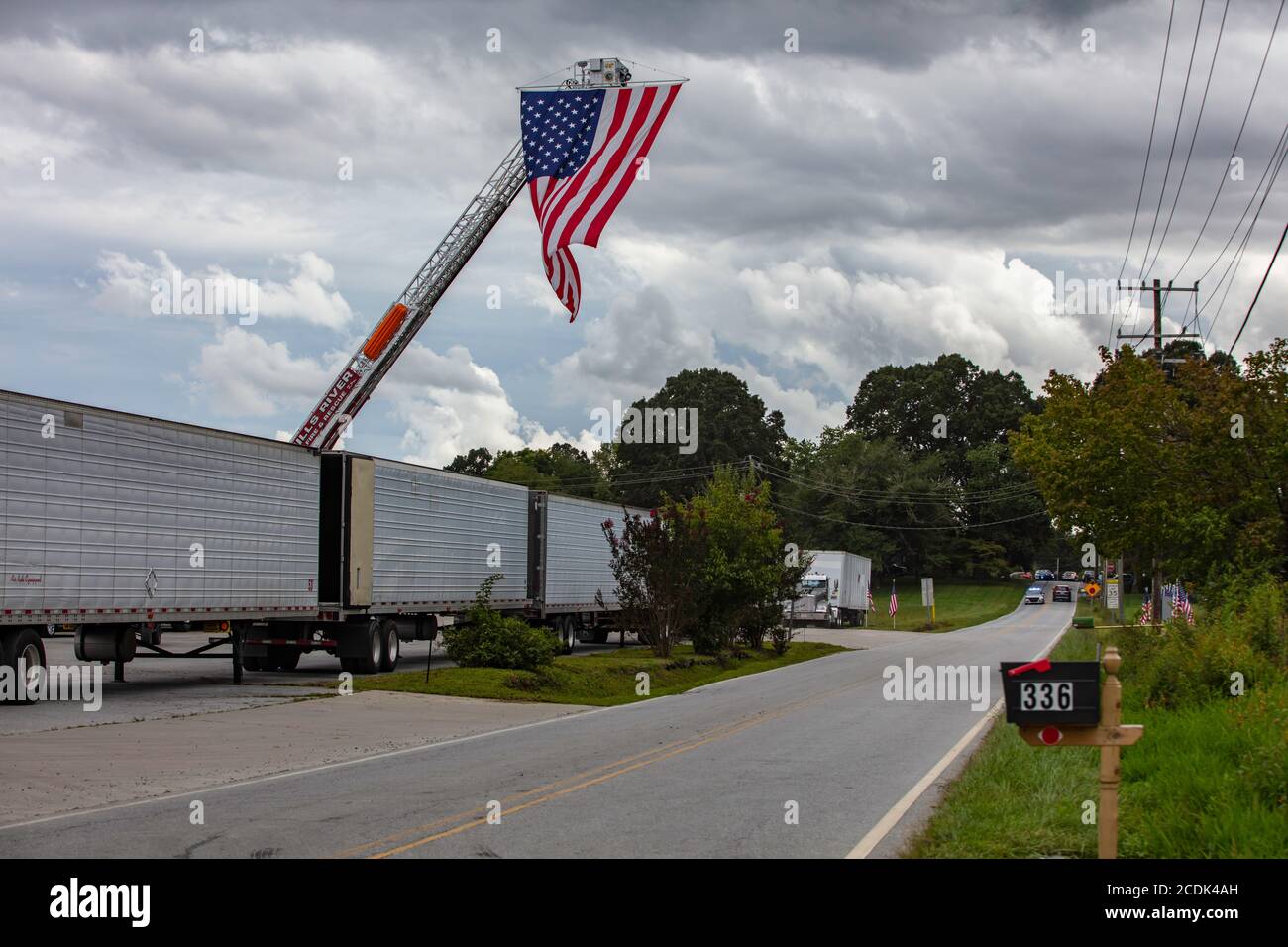 A large American flag hangs from a fire engine outside of the Farmers ...