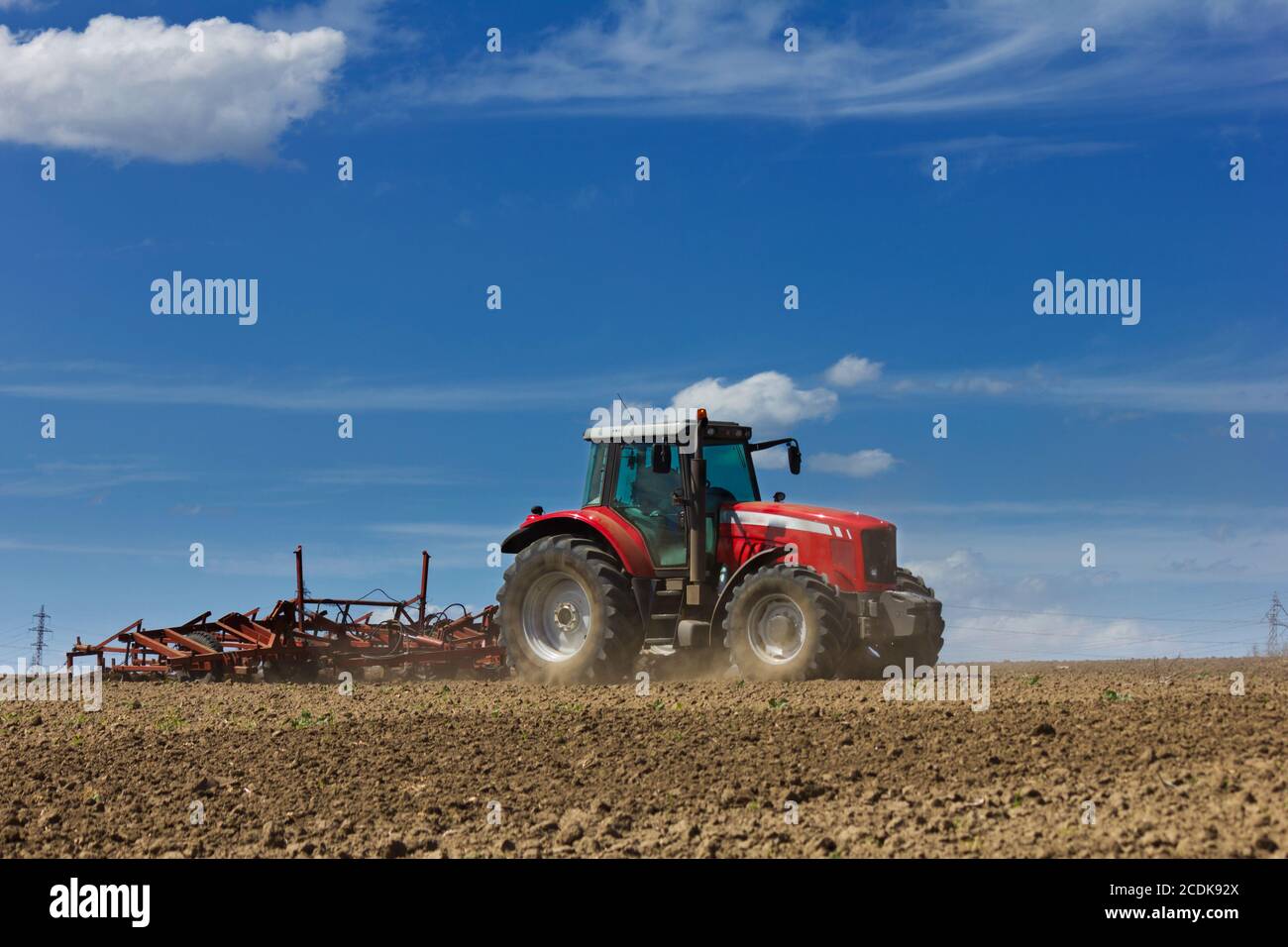 Farmer plowing the field. Cultivating tractor in the field. Red farm ...
