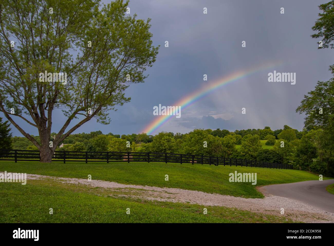 Colorful arc of a rainbow during a summer storm Stock Photo - Alamy