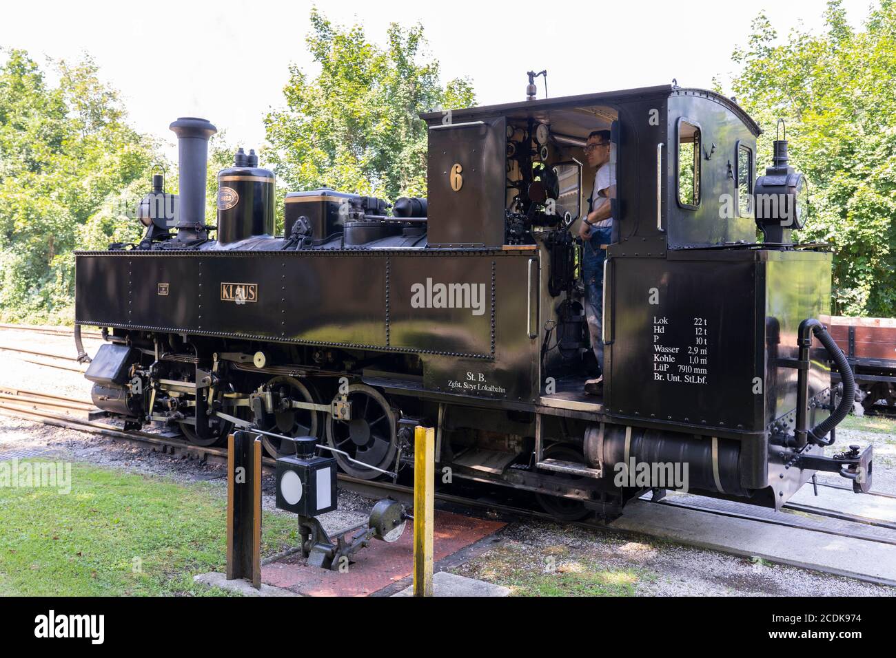 Driver in traditional working clothes on an old fashioned steam train ...