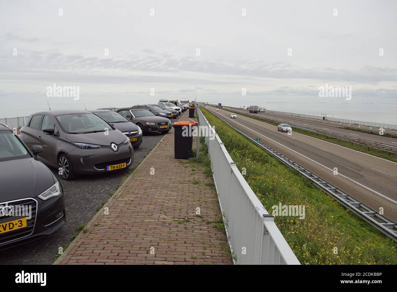 Parking space with cars to visit the monument on the Afsluitdijk. A ...