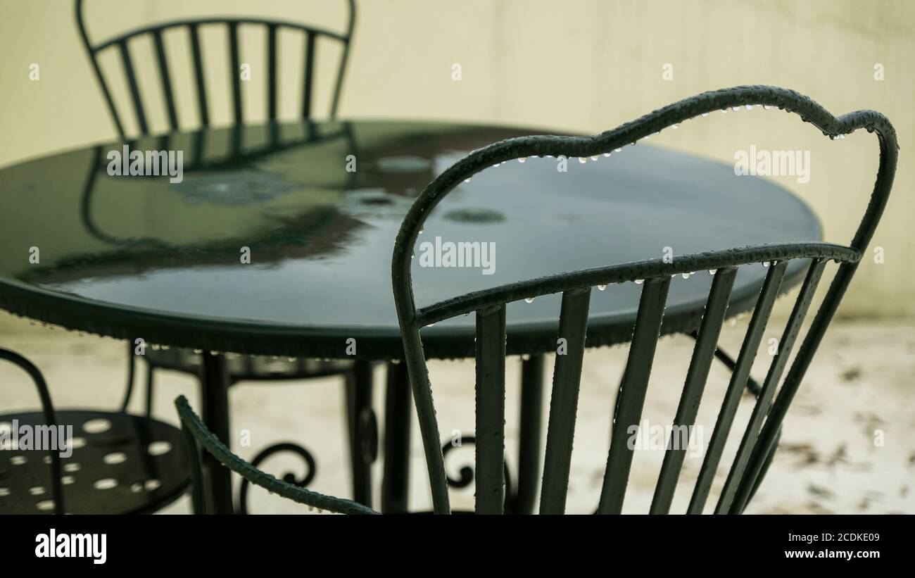 Wet garden table and chair with water drops Stock Photo - Alamy