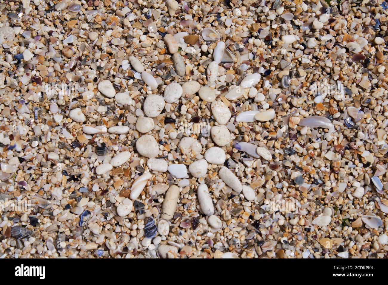 Sand background with sun from pebble Stock Photo - Alamy