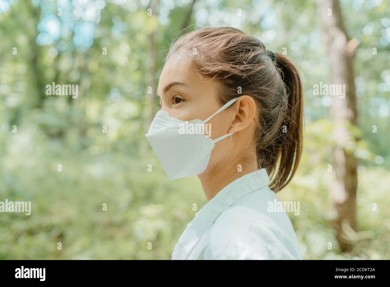 Asian woman wearing face mask walking in outdoor nature. Eco-friendly ...
