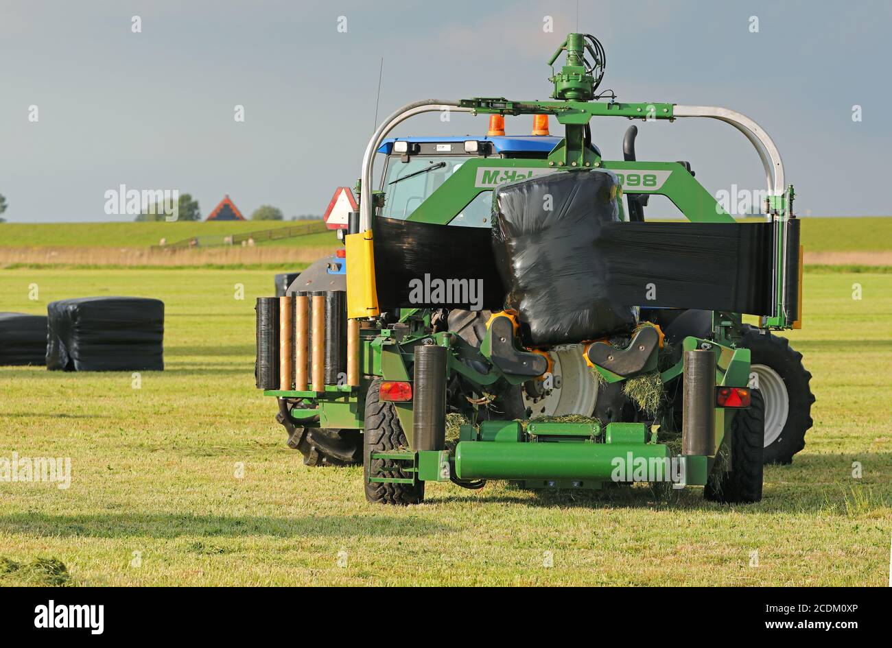 wrapping hay bales with plastic film, Netherlands, Frisia, Workum Stock ...