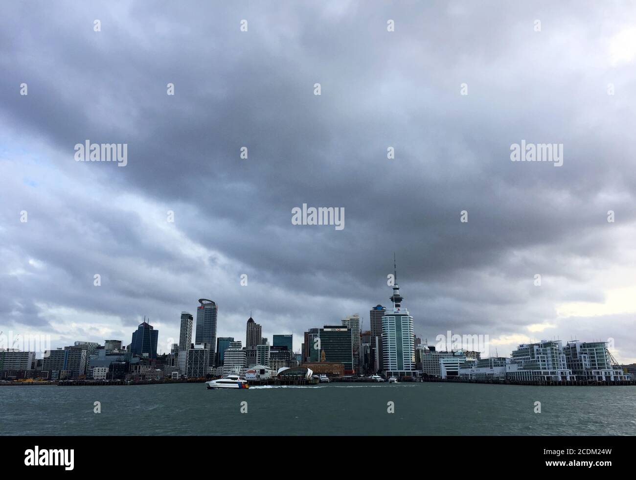 Dramatic evening sky above the Bay of Maori with skyline of Auckland ...