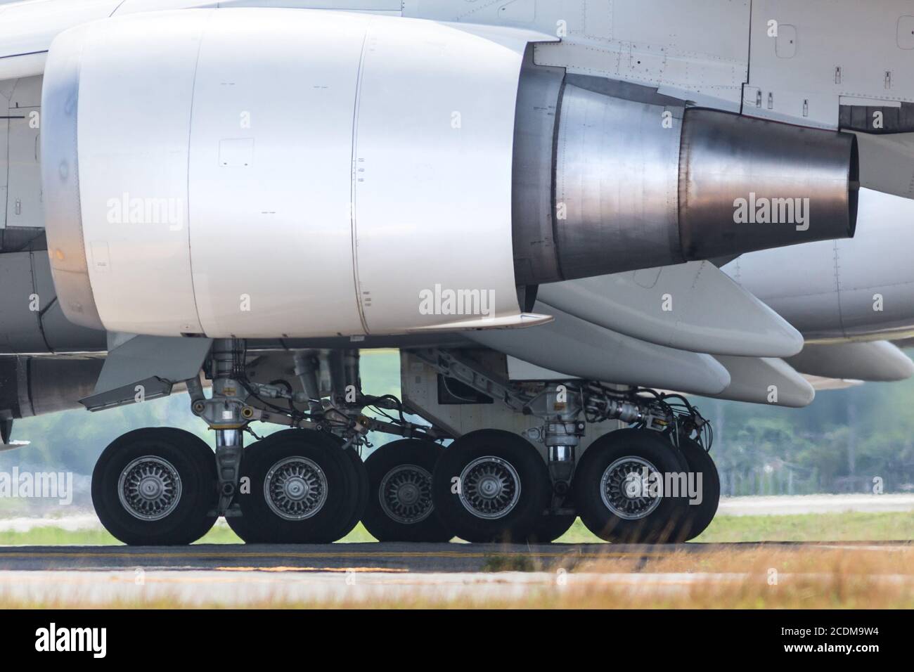 Closeup of landing gear of passenger wide-body airplane on runway, side ...