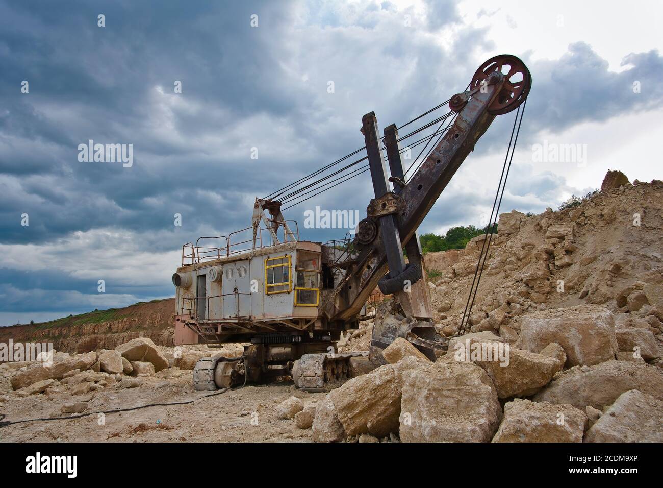 Excavator machine works in limestone pit quarry Stock Photo - Alamy