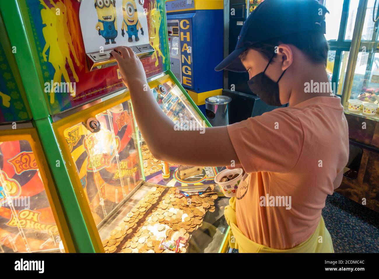 A boy plays a penny falls game in an amusement arcade while on holiday ...