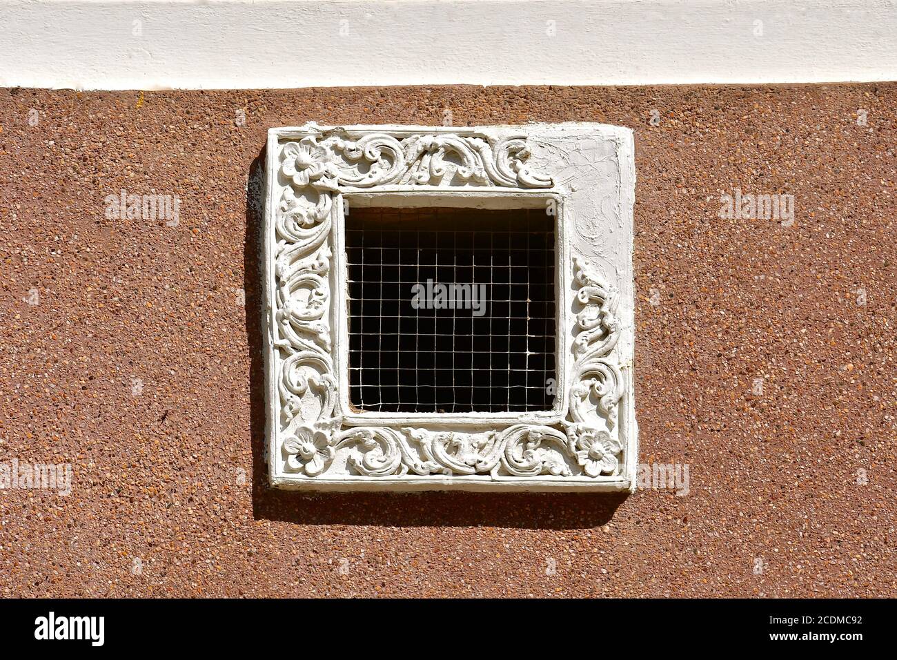 Small square ventilation vent with chicken wire grating and an ornate ...