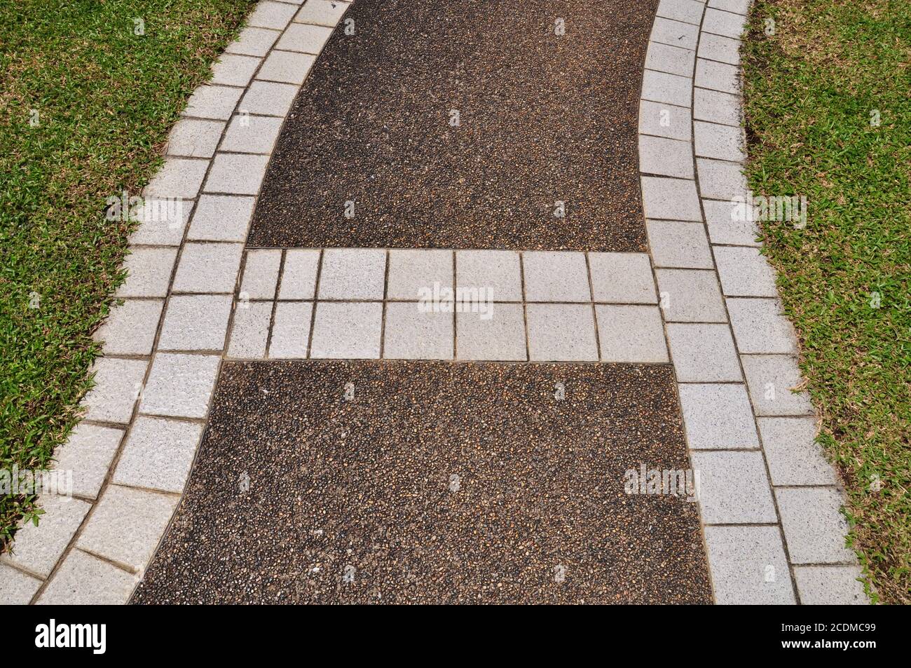 Pebbledashed and tiled footpath winding through a lawned garden Stock ...