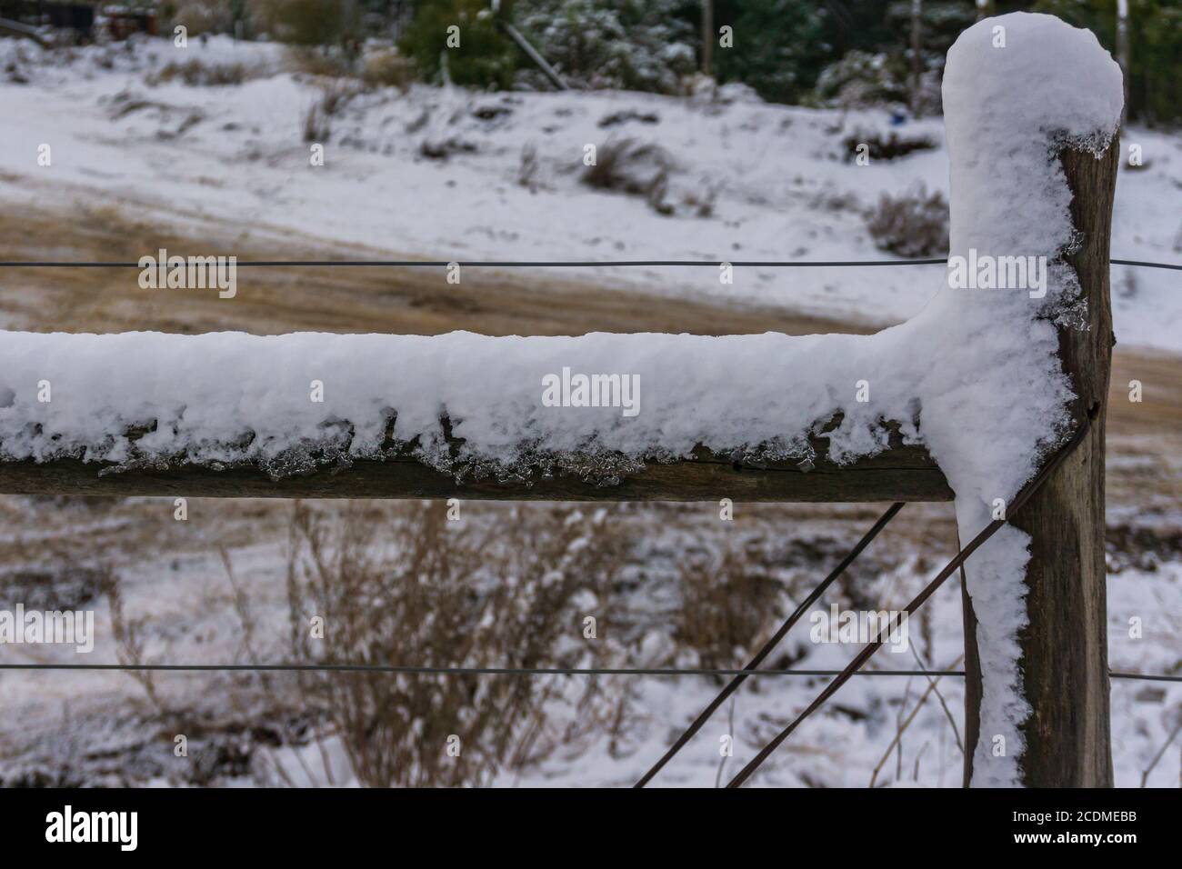 Snow covered fence after snowstorm during winter season in Esquel ...