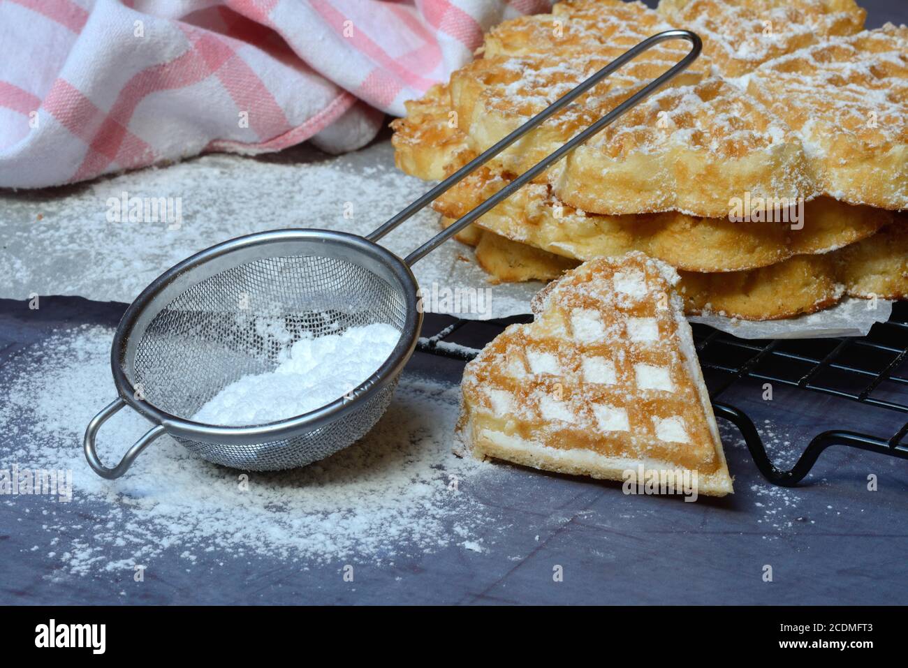 Waffles on cake rack and sieve with icing sugar, Germany Stock Photo ...