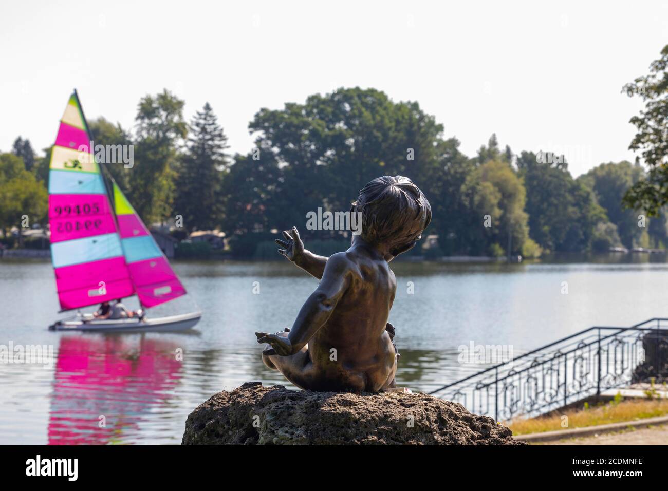 Statue on the beach promenade at Waginger See with sailing boat, Waging ...