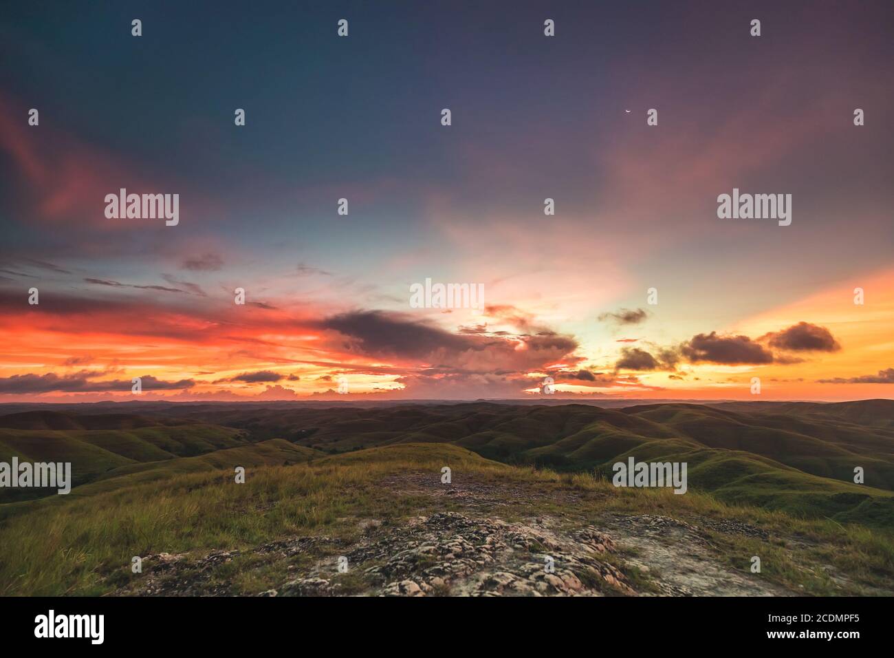 Indonesia sunset, green hills landscape under colourful sky in evening ...