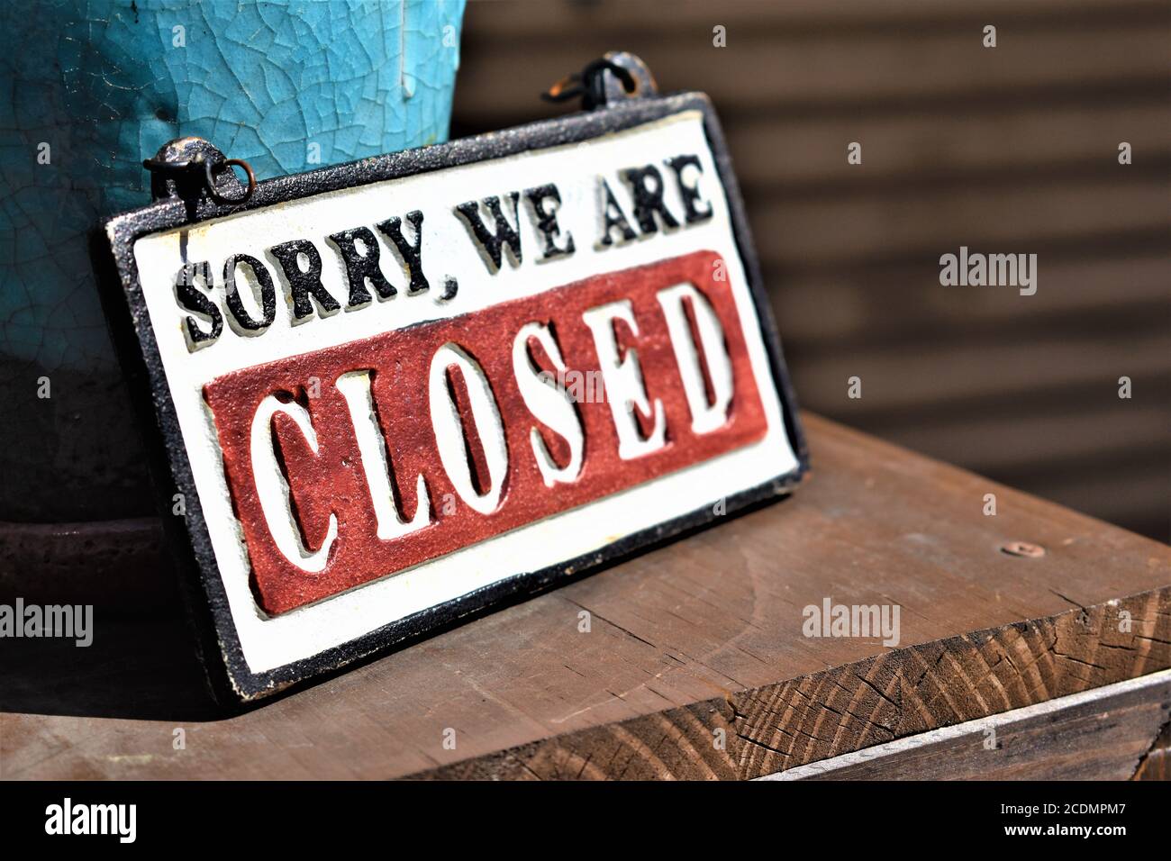 A signage that says Sorry, We Are Closed sits on top of a desk by a ...