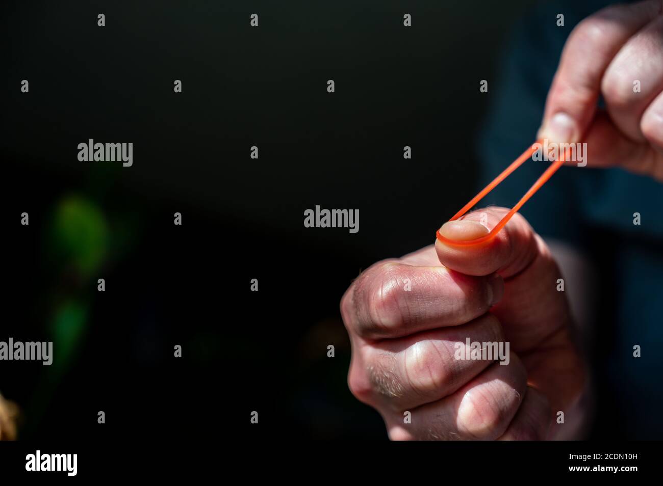 Shooting a rubber band by pulling an elastic material and letting go ...