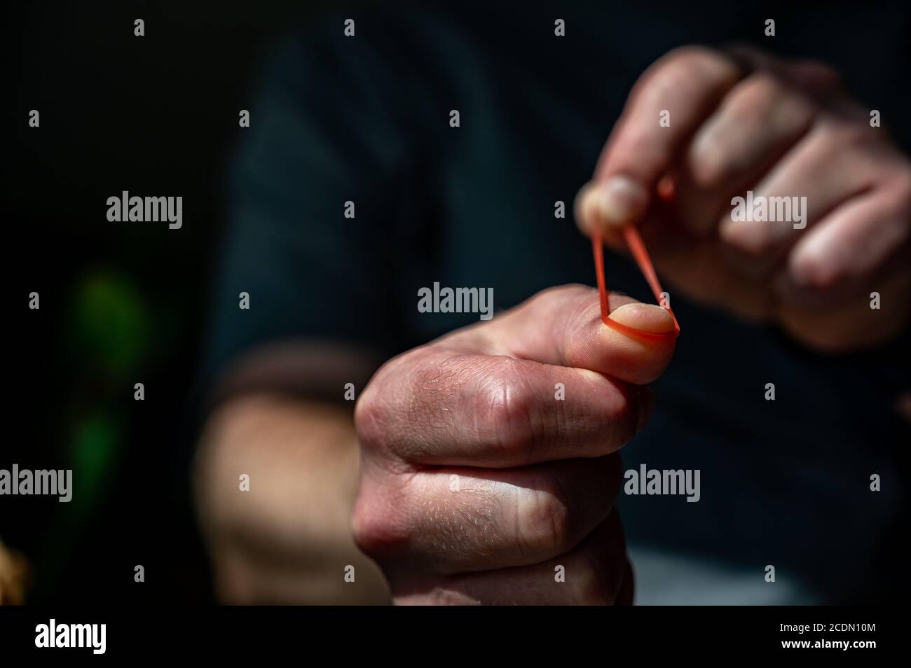 Shooting a rubber band by pulling an elastic material and letting go ...