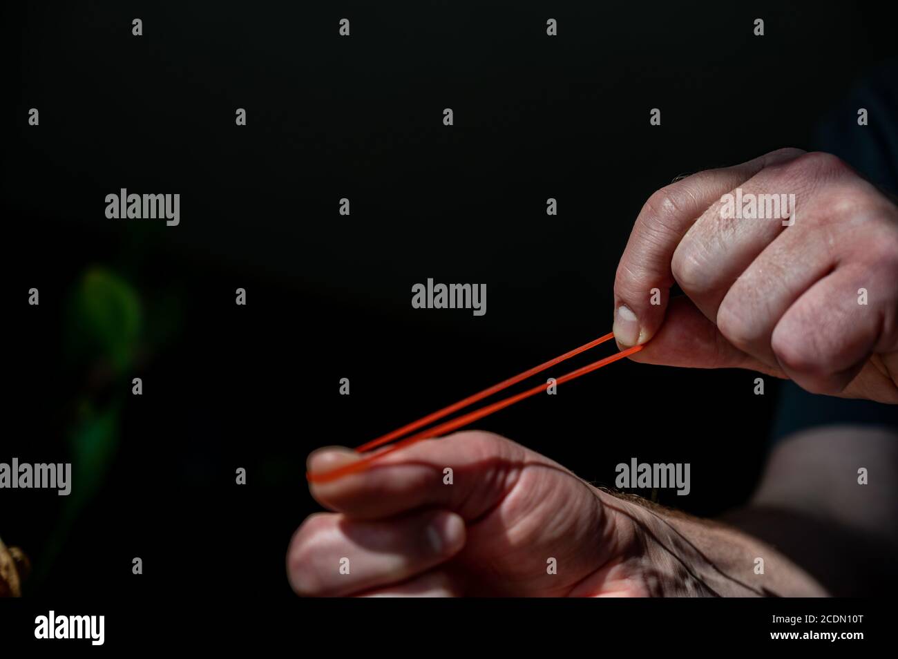 Shooting a rubber band by pulling an elastic material and letting go ...