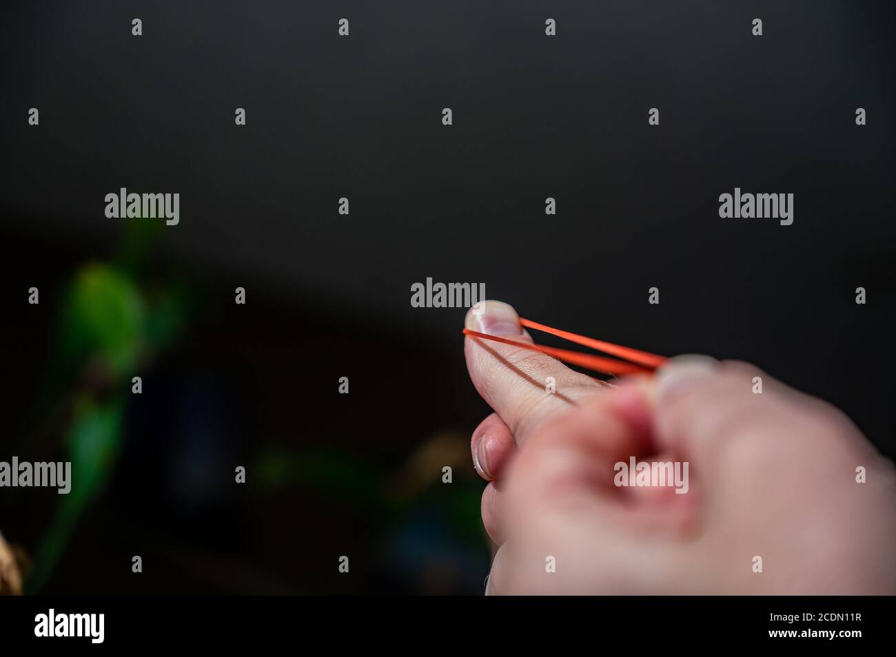 Shooting a rubber band by pulling an elastic material and letting go ...