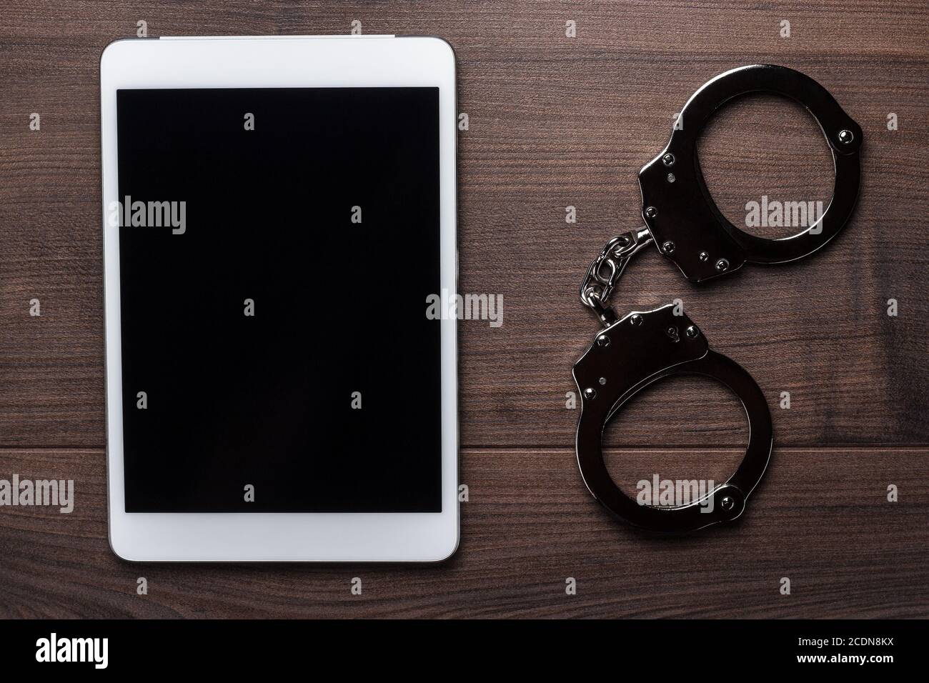 handcuffs and tablet computer Stock Photo - Alamy
