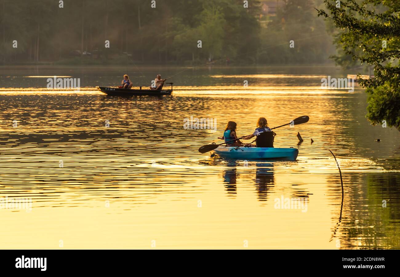 A beautiful, golden sunset evening for families fishing and kayaking on ...