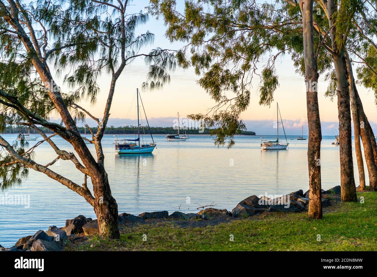 Boats anchored in Burrum river at sunset, Burrum Heads, Queensland ...