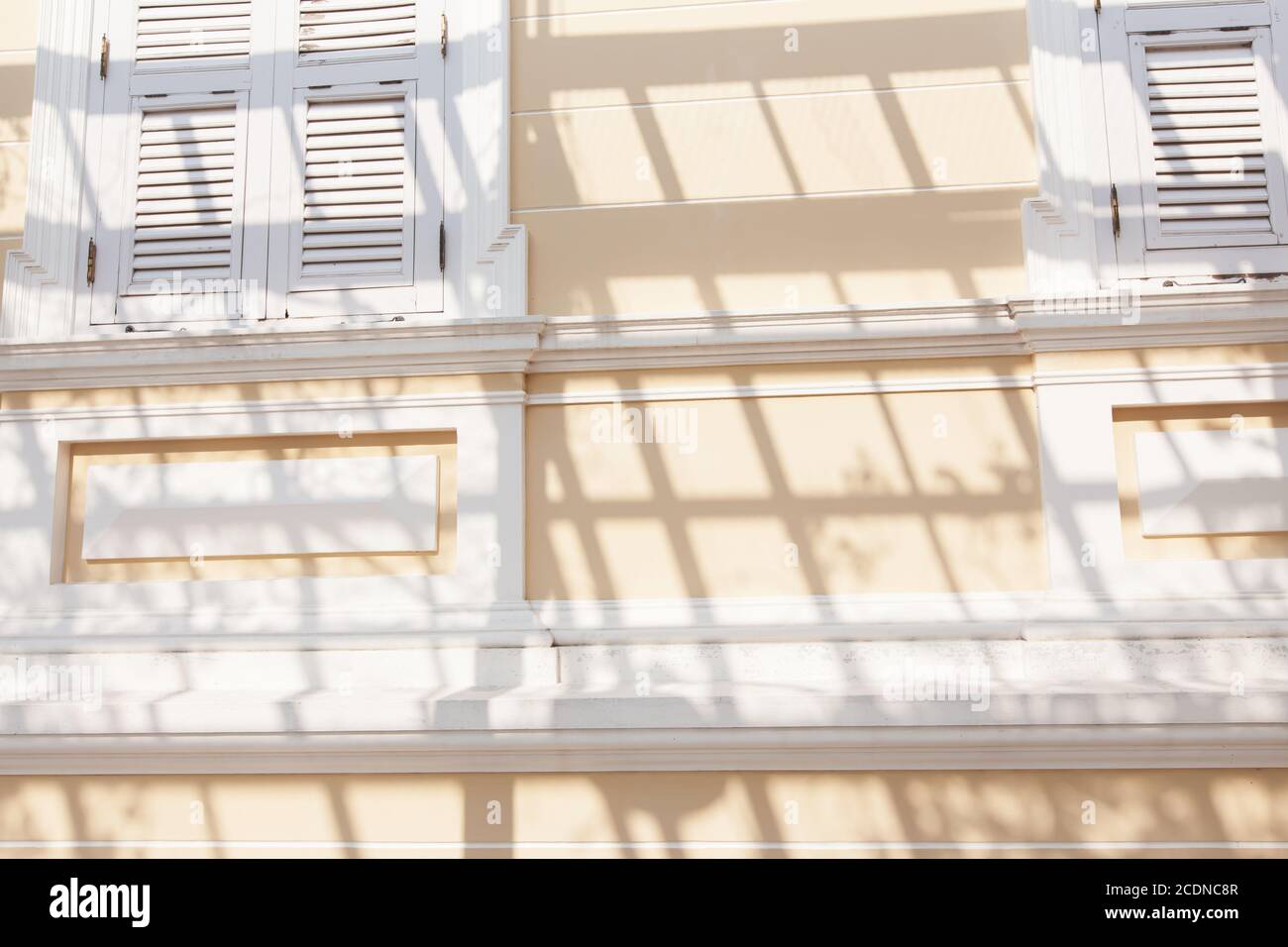 Colonial style facade of residential building with striped shadow ...