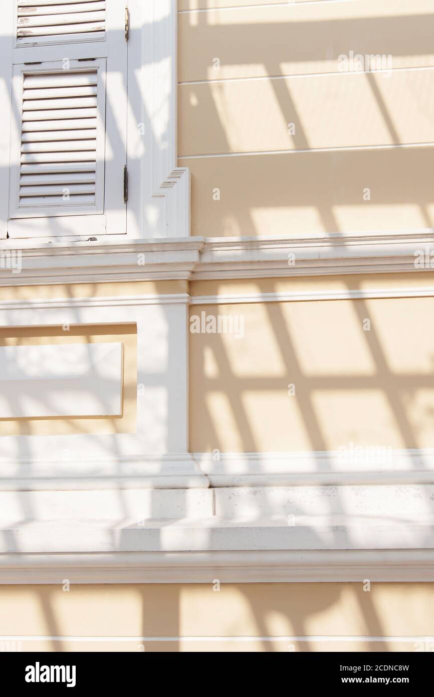 Colonial style facade of residential building with striped shadow ...