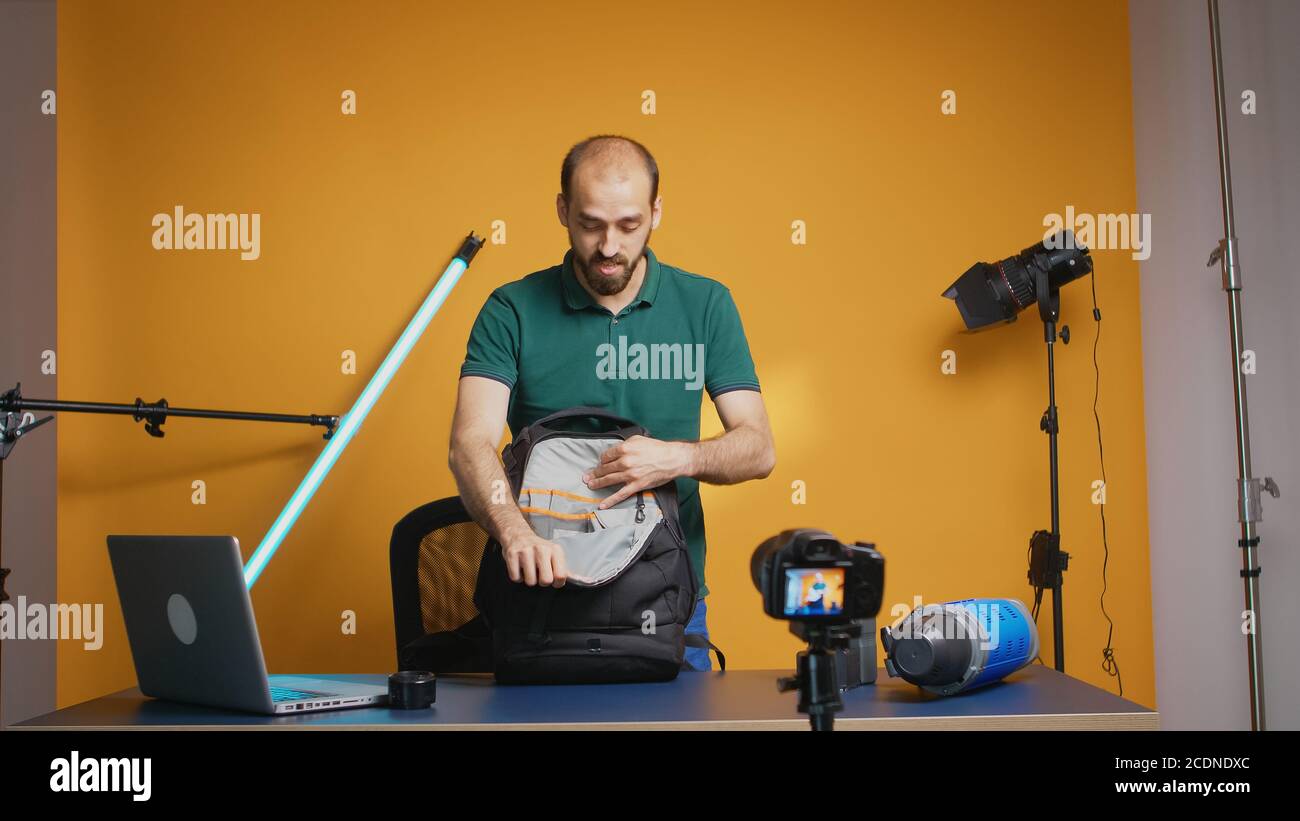 Professional photographer presenting backpack for lenses and camera ...