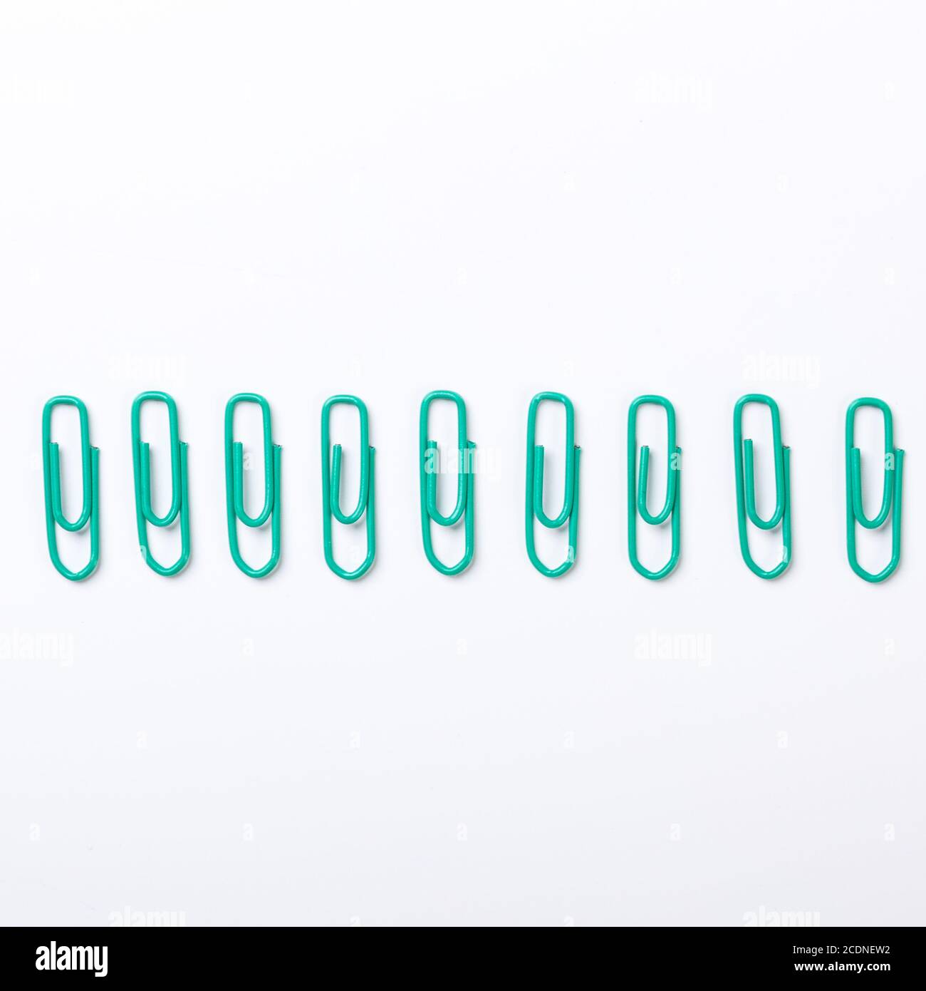 Image of green paper clips isolated on white background Stock Photo - Alamy