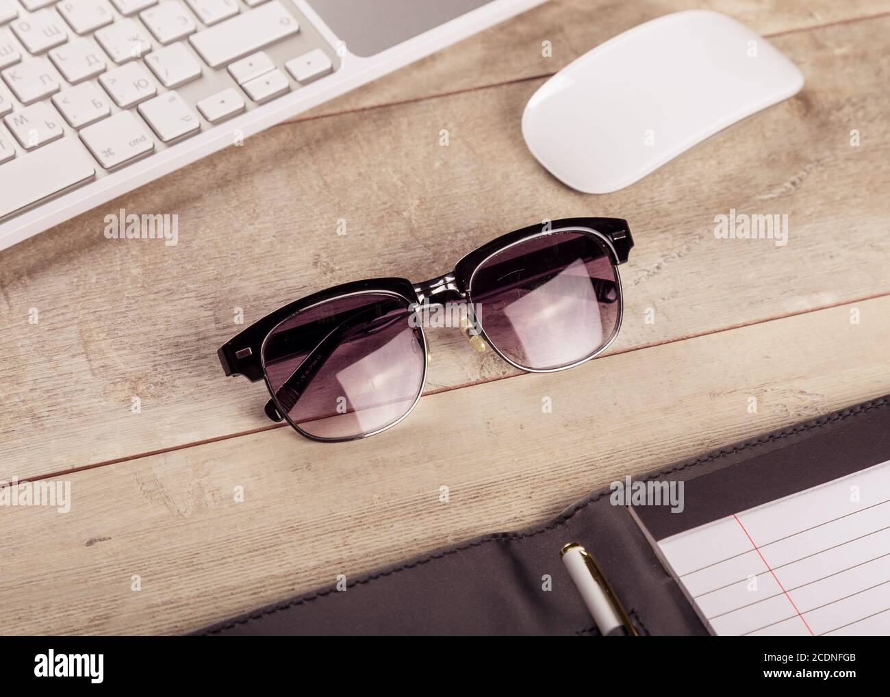 Office desk table with computer, and glasses Stock Photo - Alamy